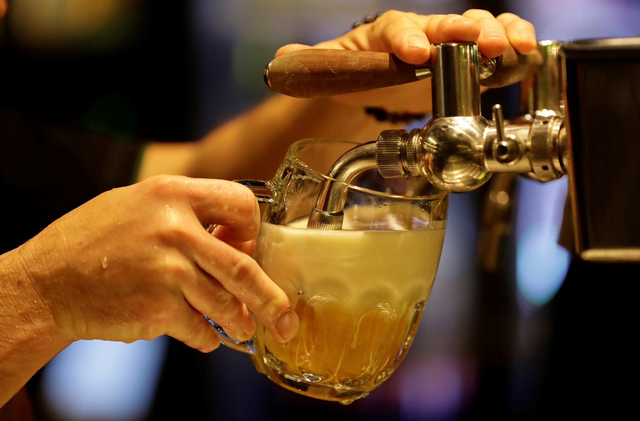 A bartender pours a glass of beer inside of a new conceptual pub by ...